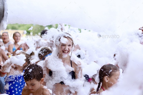 Group of people having fun, enjoying and dancing at a foam party in ...