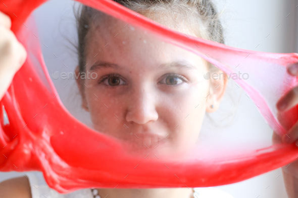 Young girl holding bright red slime in her hands. Education, creativity ...