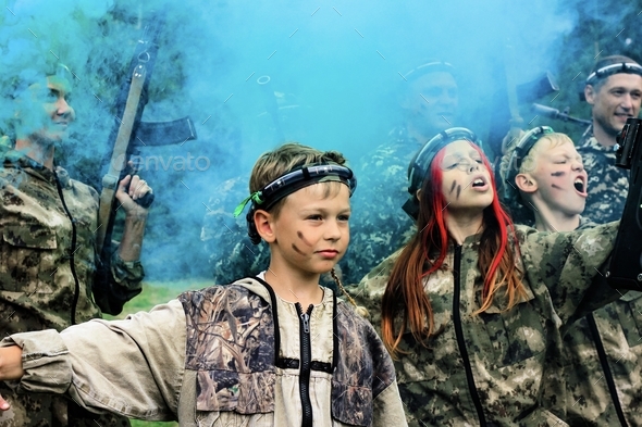 People in camouflage celebrating winning laser tag shooting game with ...