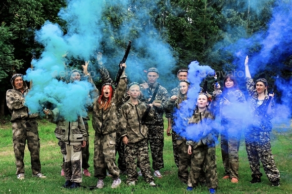 People in camouflage celebrating winning laser tag shooting game with ...