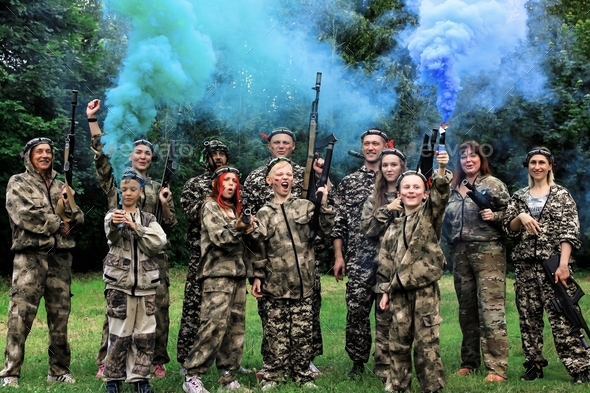 People in camouflage celebrating winning laser tag shooting game with ...