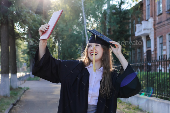 Cute teenage graduate girl laughing and having fun. No school, back to ...