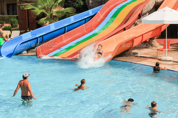 Water aqua park in the hotel. People having fun in the swimming pool ...