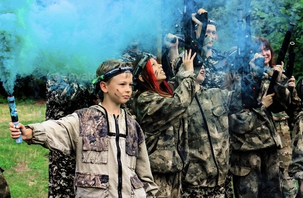 People in camouflage celebrating winning laser tag shooting game with ...