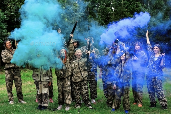 People in camouflage celebrating winning laser tag shooting game with ...