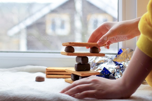 A pyramid of cookies and candies built by a teenage girl bored during ...