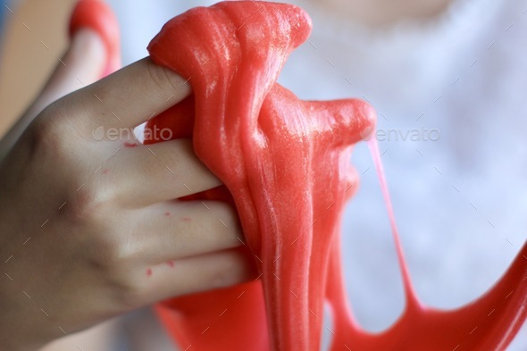 Bright red slime in children's hands. Education, creativity, childhood ...