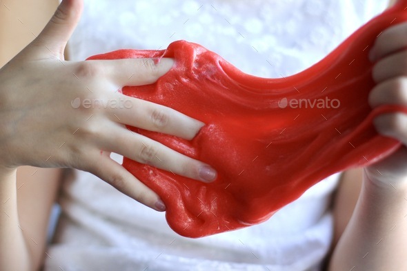 Bright red slime in children's hands. Education, creativity, childhood ...