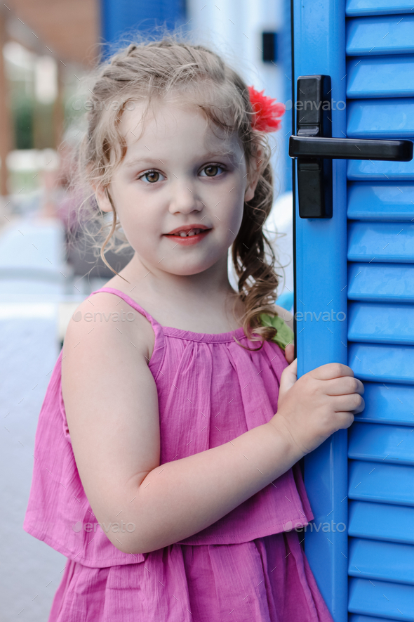 Close up soft focus portrait of cute little girl in bright violet dress ...