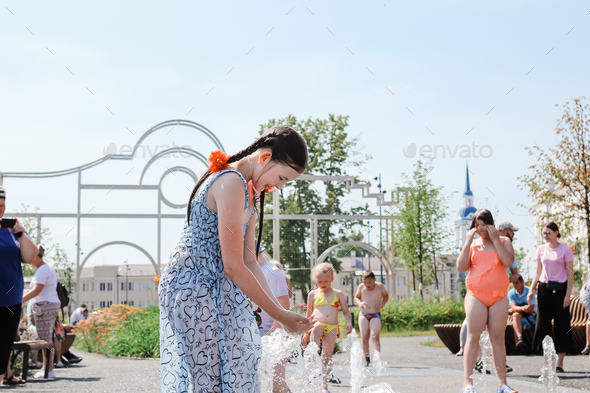 Cute funny girl in summer dress walking and having fun in water park ...