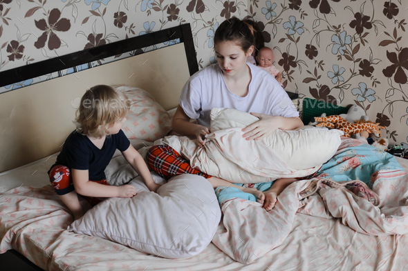 Children helping with cleaning the house, removing bed linen. Lifestyle, siblings, brother ...