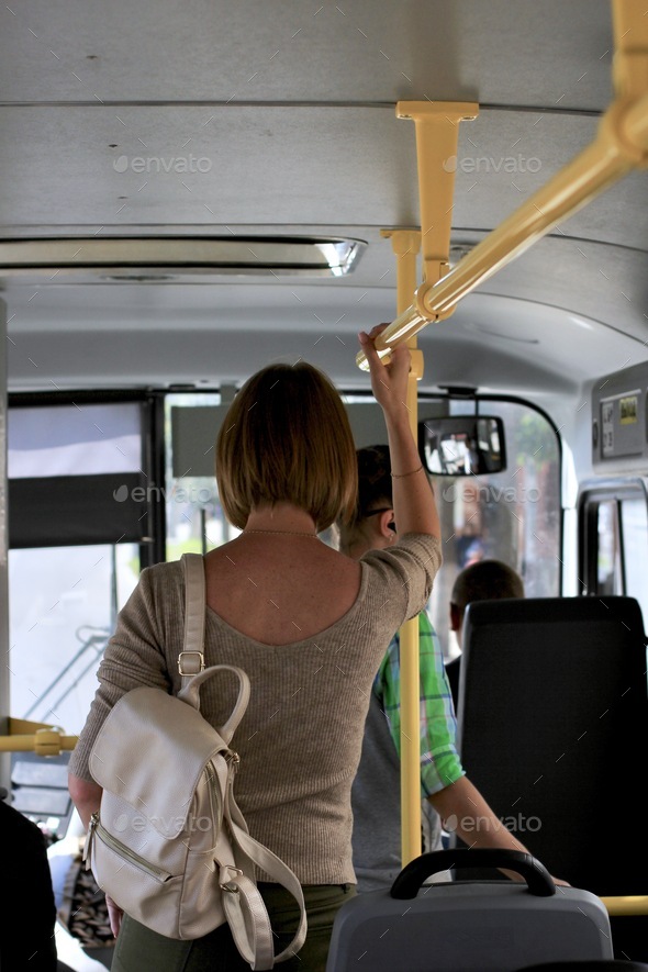 People go in public transport in the afternoon on a weekday. Woman ...
