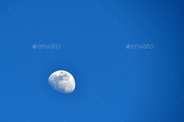 Daytime moon - a partial moon in a bright blue sky during the day Stock ...
