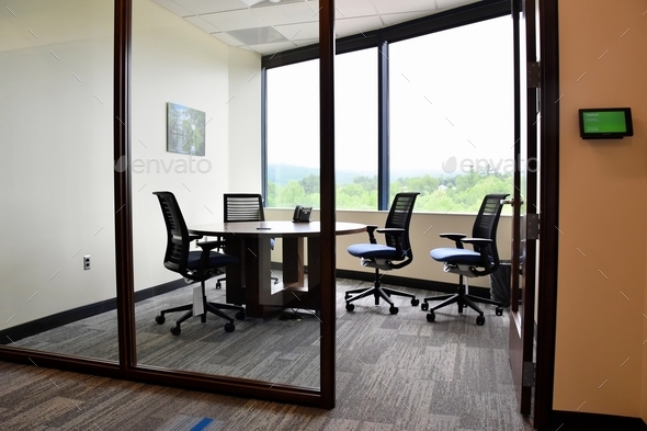 A clean bright modern conference room at work where employees can hold ...