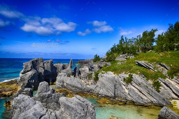 Rocks and pinks sand leading down to the clear blue waters off the ...