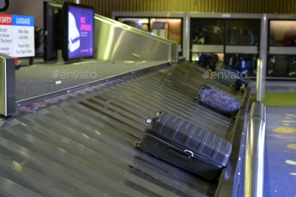 Suitcases on the luggage carousel in the baggage claim area of an ...