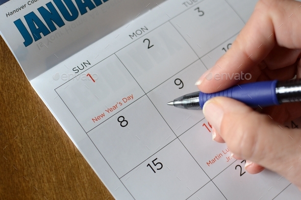 Writing appointments in a planner calendar. Stock Photo by MargJohnsonVA
