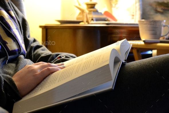Female teenager reading a textbook book studying for class test. High ...
