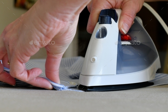 Ironing a dress shirt on an ironing board. Hot iron, laundry day, doing ...