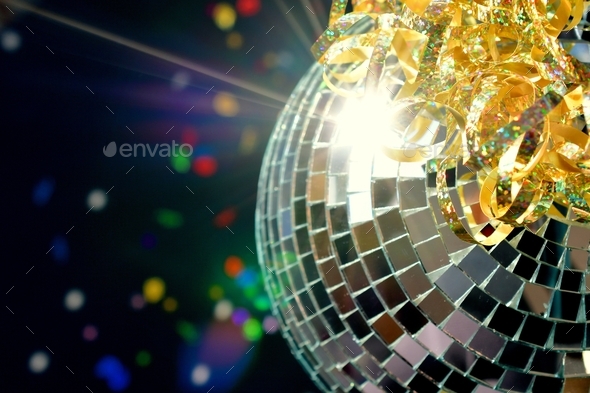 Shiny retro disco ball sparkling in light with festive glittery ribbon ...