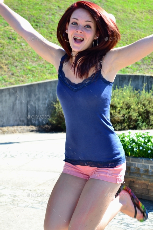 A Laughing Smiling Gen Z Teen Female Teenager Girl With Dyed Red Hair And Silver Dental Braces