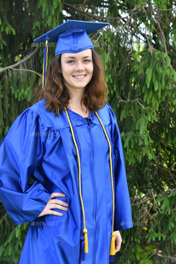 A young female teenager Gen-Z posing before graduation wearing a cap ...