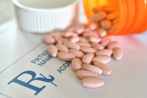 Pink oval pills medicine pharmaceutical drugs laying on a prescription ...