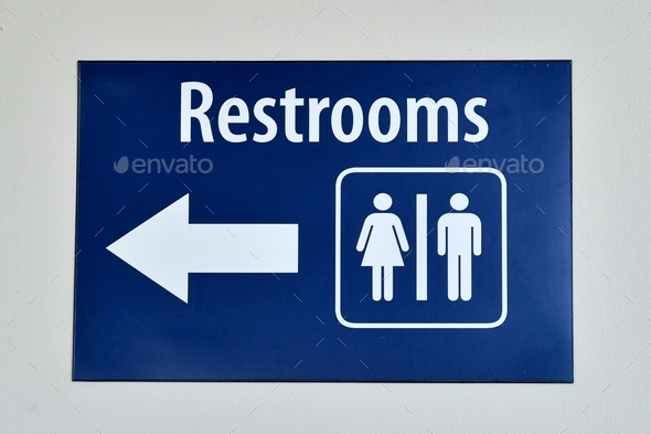 A public restroom sign with a male and female symbol pointing in right ...