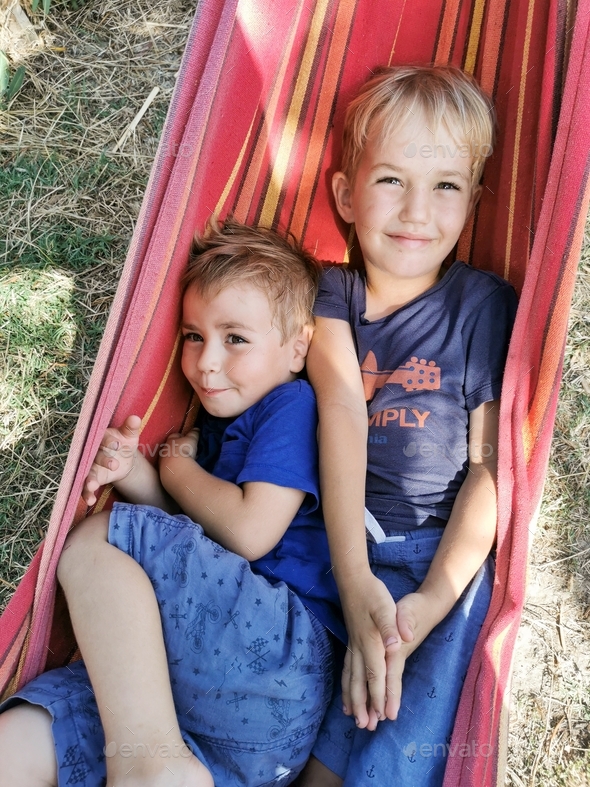 Two little brothers spend time in a hammock in the garden. Stock Photo ...