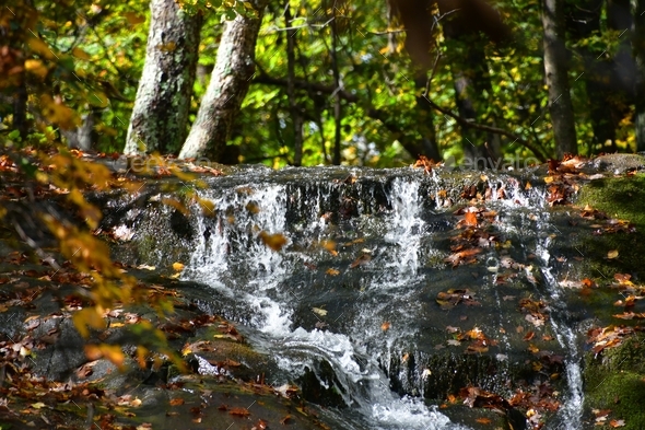 Fresh mountain spring water flowing over the rocks in a waterfall ...