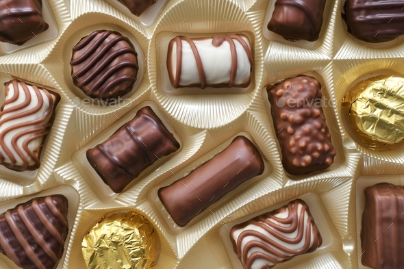 Assorted elegant chocolates in a gold container - full frame background ...