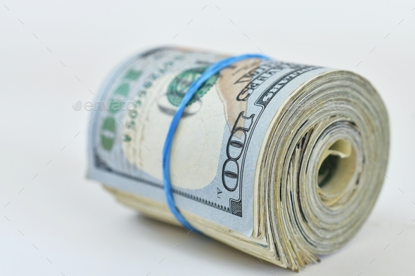 Roll of cash money US 100 dollar bills with rubber band around it on ...