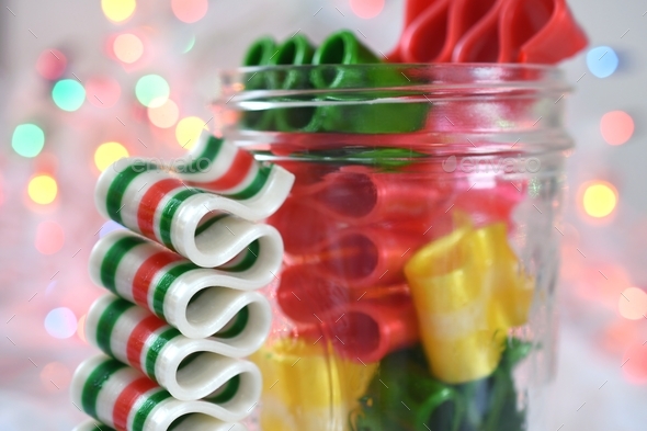 Colorful Christmas ribbon candy in a jar with colored lights bokeh ...