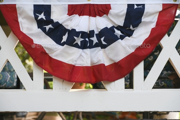 American flag bunting hanging on railing of a front porch of a home ...