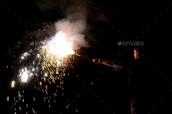 Man shooting off fireworks in celebration Stock Photo by MargJohnsonVA
