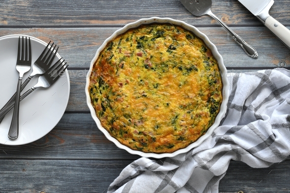 A ham, cheese & spinach quiche. Flat lay of cooked quiche on table for ...