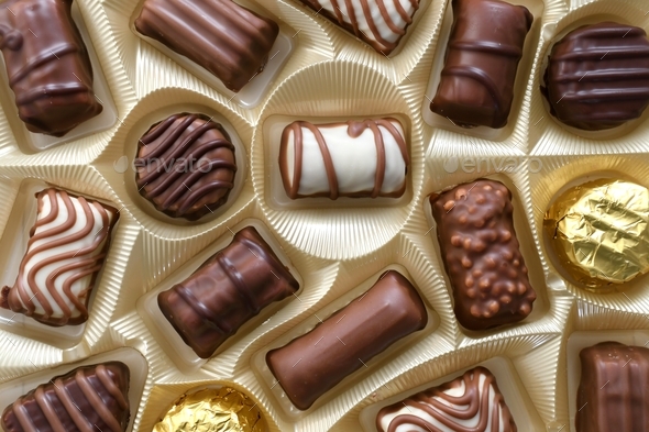 Assorted elegant chocolates in a gold container - full frame background ...