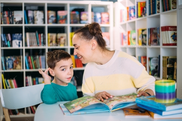 Mom and her little child, preschooler son, reading books together ...