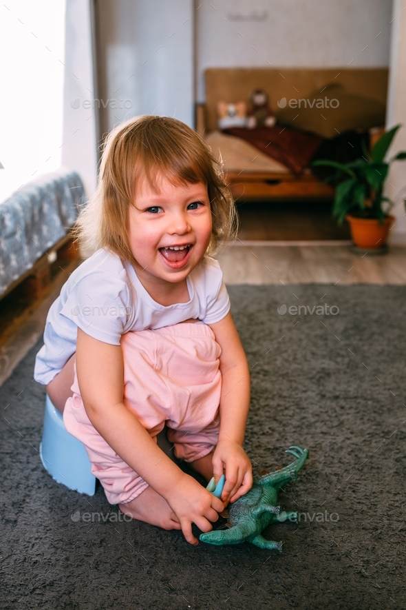 Cute toddler girl, potty training, playing with his toys on potty ...