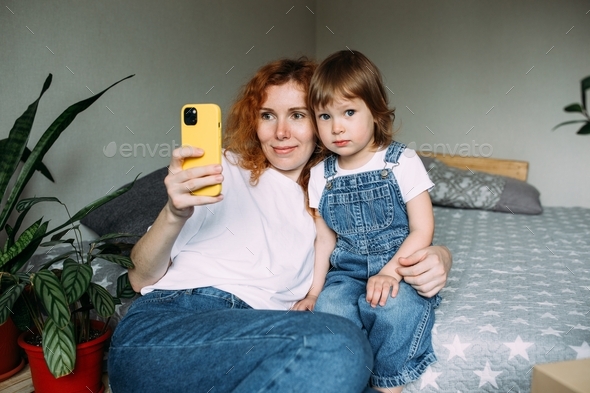 Young mother and child take photo together at home, have fun ...