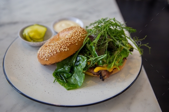 Tasty fresh bagel with green salad, egg and smoked beef wtih mayo on ...