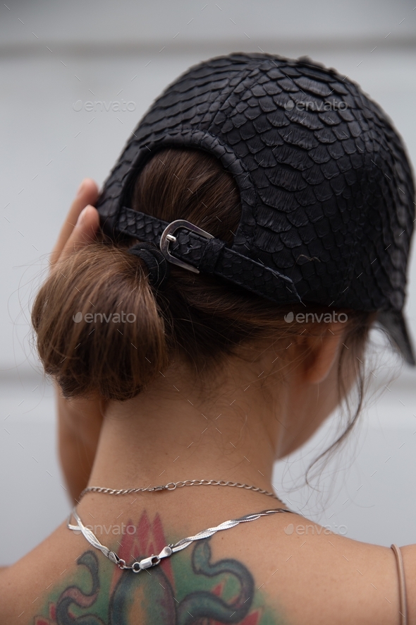 Cropped photo of woman wearing leather cap. People from behind Stock ...