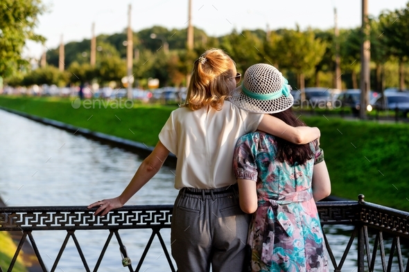 Kind hug. Mother and daughter enjoying summer in the city near the ...