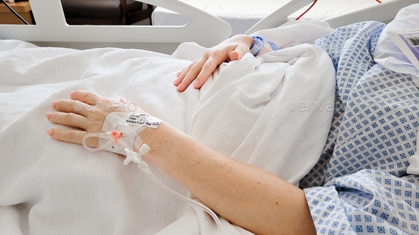 Woman in a hospital bed after surgery, hands in frame Stock Photo by ...