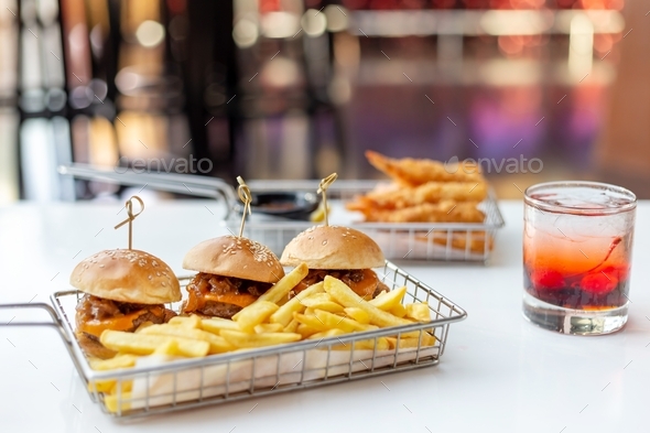 Mini burgers with french fries and cocktail served at the bar, finger ...