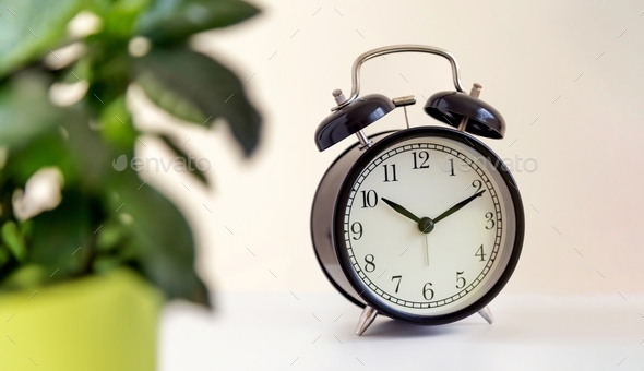 Classic desk alarm clock showing eleven past ten in the morning, green ...