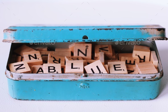 Scrabble tiles spelling word BLUE inside an old blue rustic tin box ...