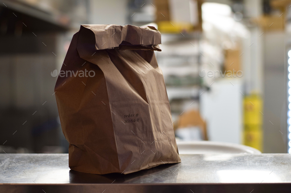 Brown paper bag with take out food order ready to be picked up on ...