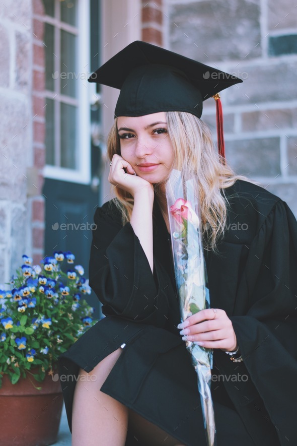 portrait of girl graduate sitting on front steps of house wearing ...