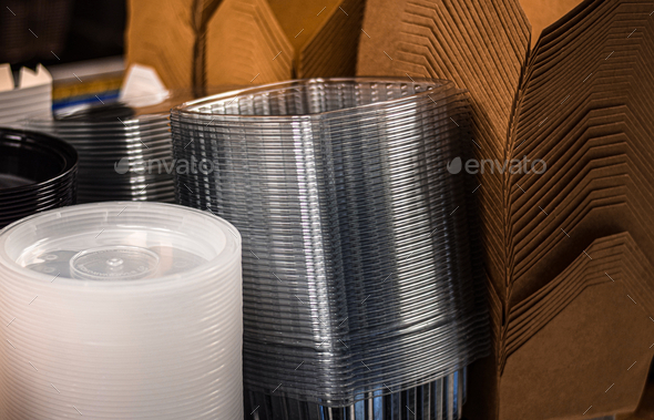 Stacks of paper and plastic take out disposable containers on a ...